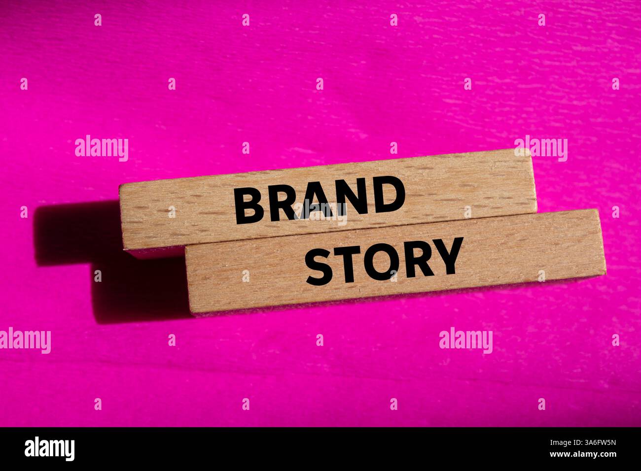 Brand story message written on wooden blocks on pink background ...