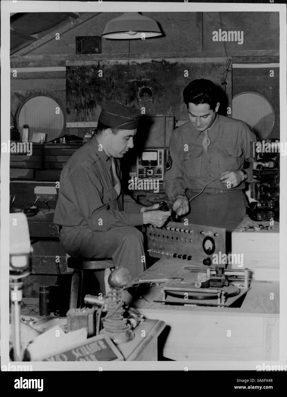 Warrant Officer Norman W. Schauer and Sergeant Carter McCuan work on a ...