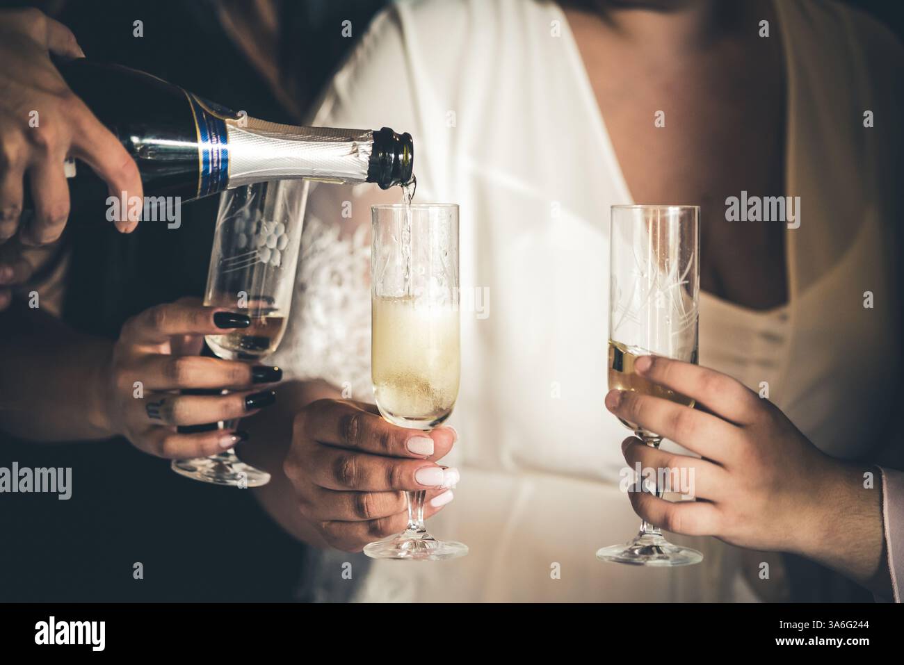 Bride drinking champagne with her friends white getting ready for the ...