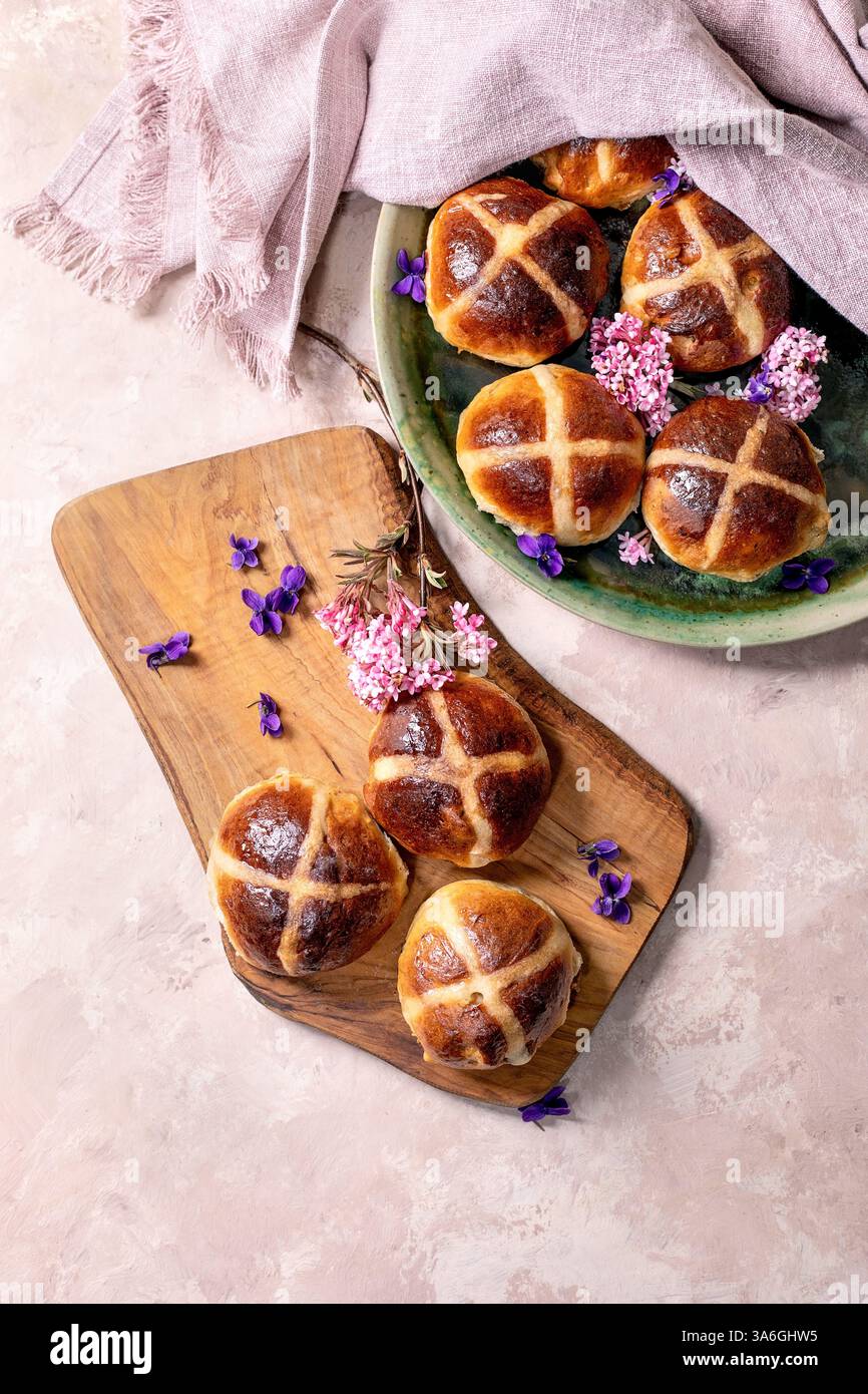 Hot cross buns served on wooden board and ceramic plate. Easter ...