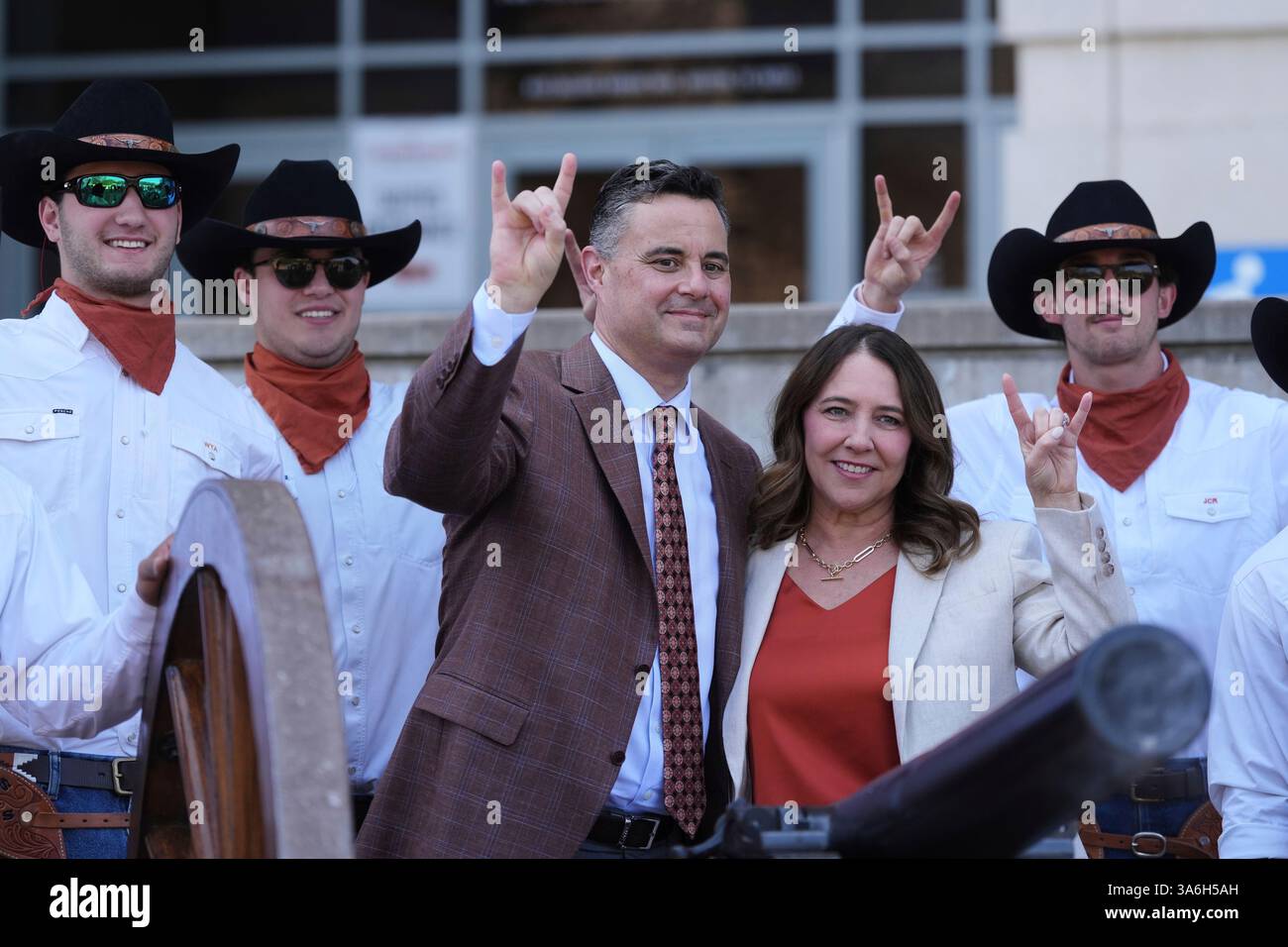 Texas' new head coach Sean Miller, center, with his wife Amy, pose for ...