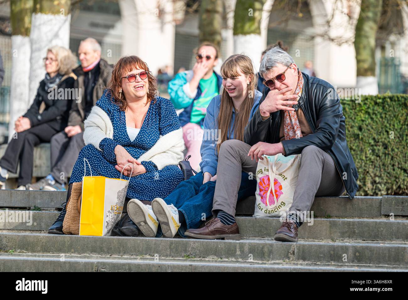 Family with mother, father and teenage daughter sitting on the stairs ...