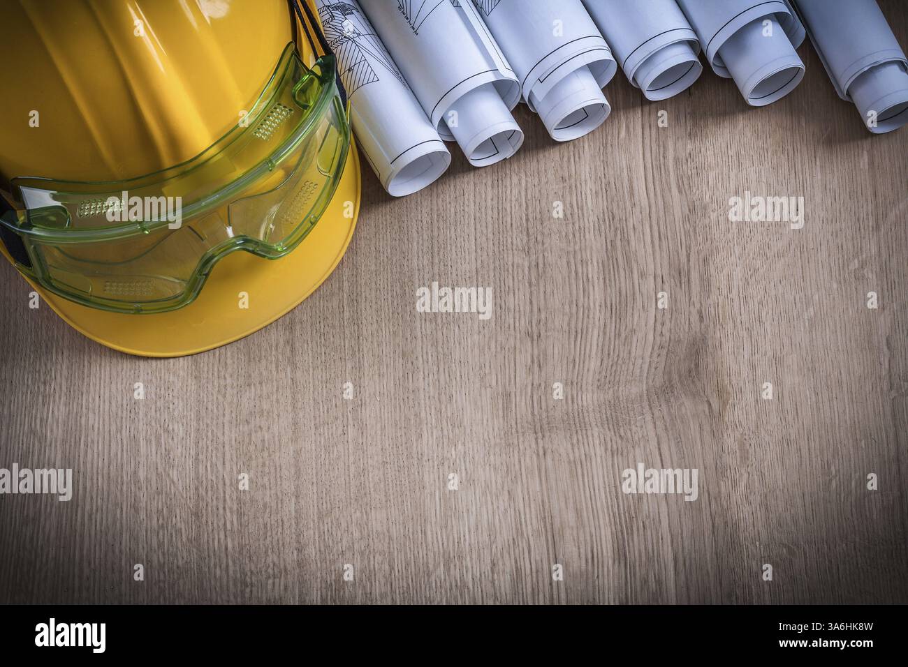 Safety spectacles rolled blueprints and hard hat construction concept ...