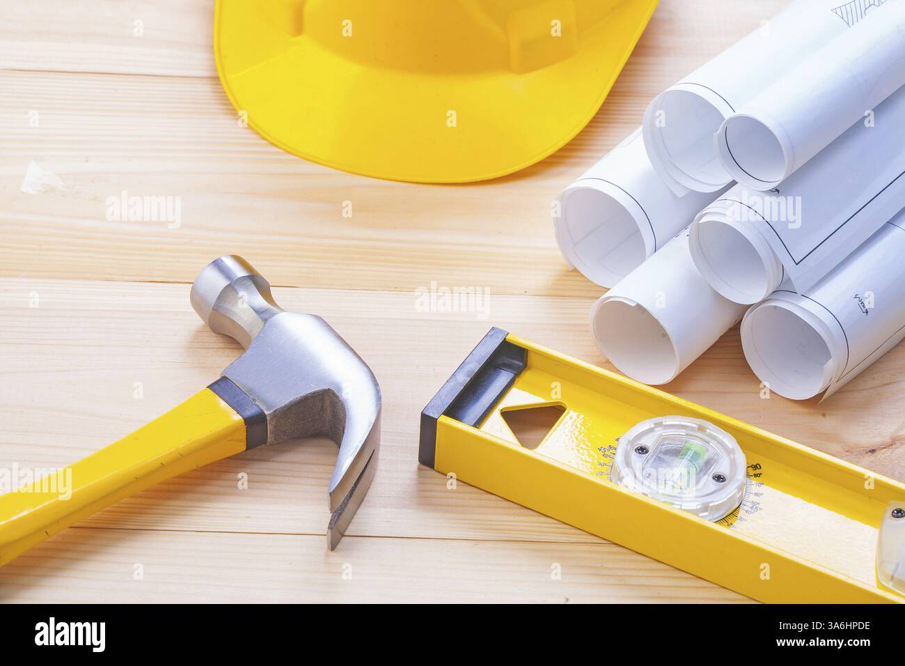 Claw hammer rolled blueprints construction level hardhat on wooden ...