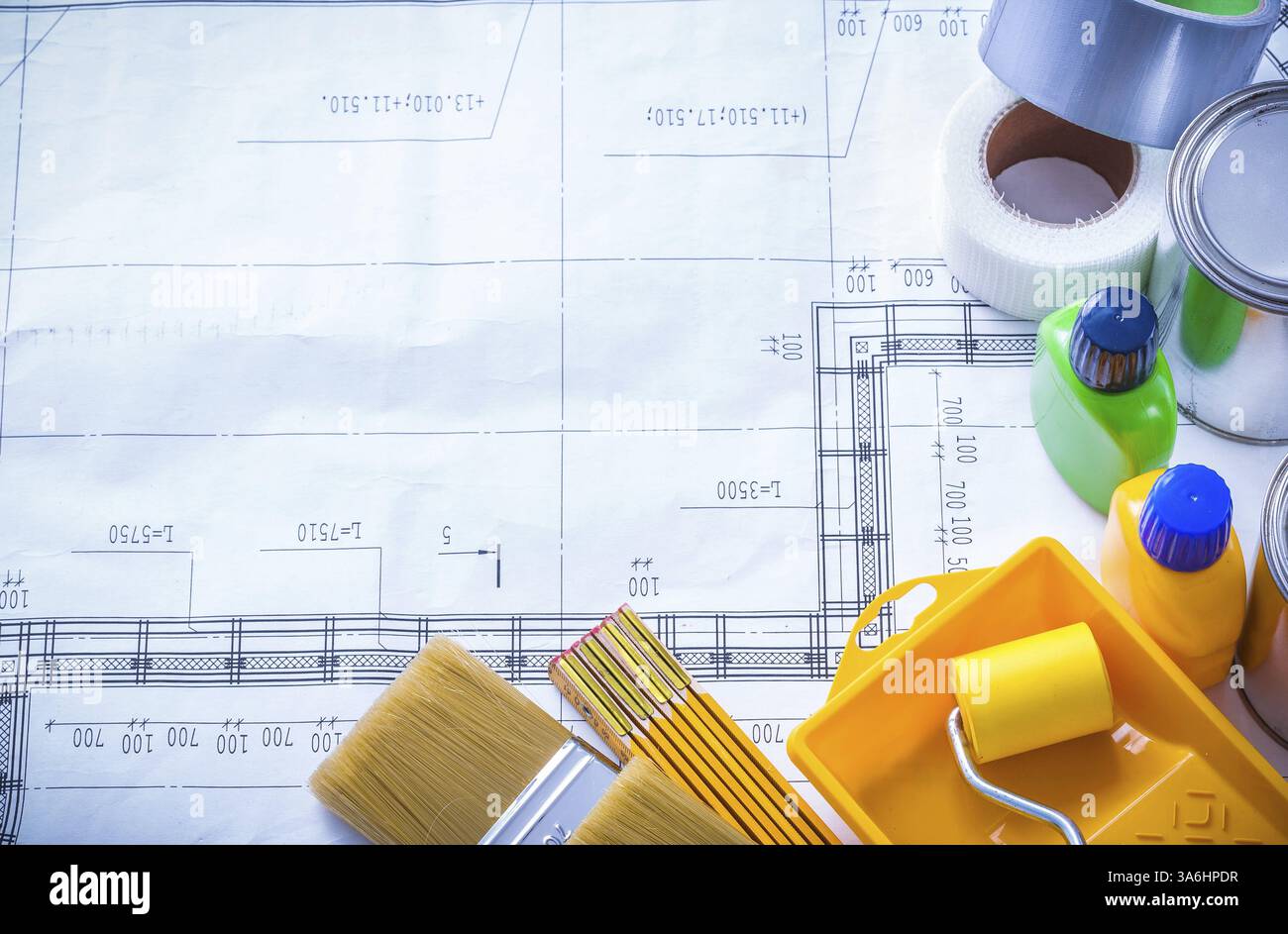 Duct tape wooden meter and paint tools on construction drawing vertical ...