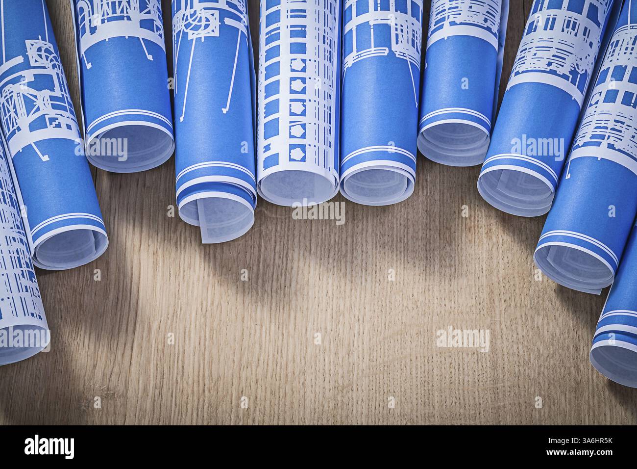 Set of blue rolled engineering drawings on wood board construction ...