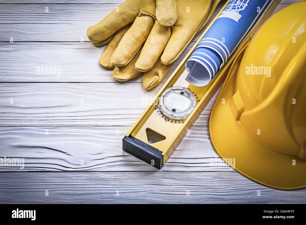 Safety gloves hard hat blue engineering drawings construction level on ...