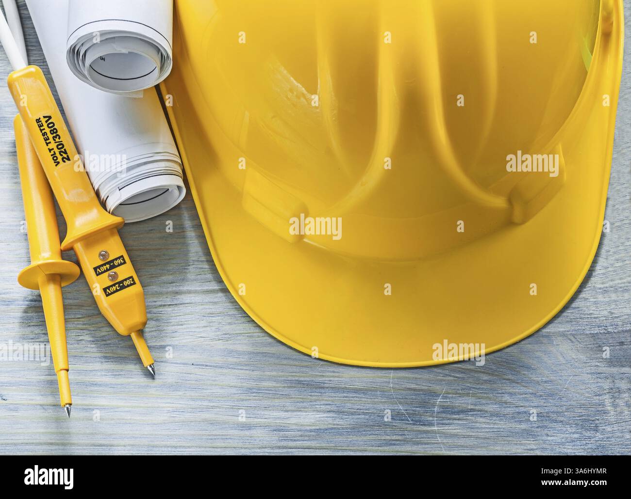 Electric tester protective hard hat engineering drawings on wood board ...