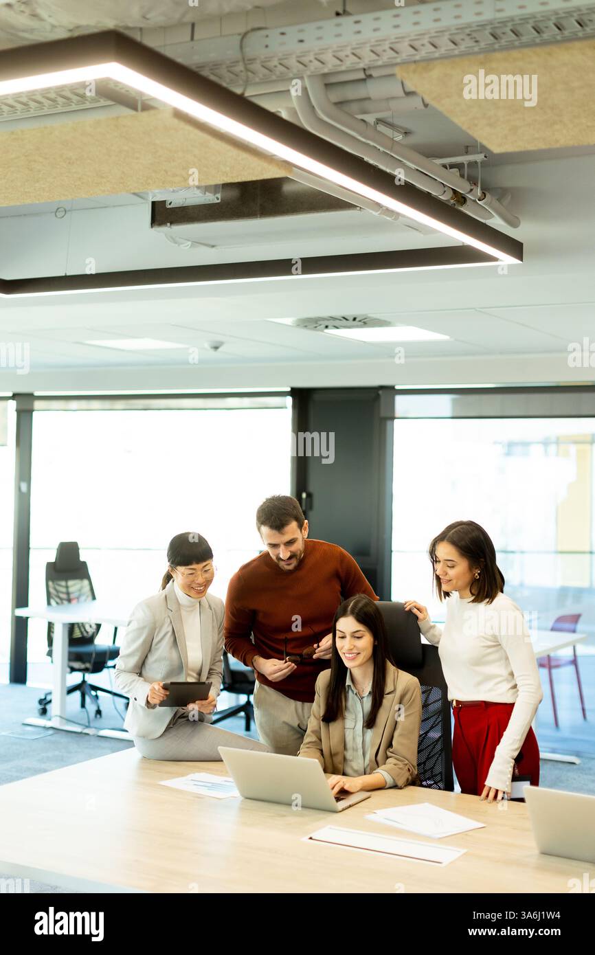 In a contemporary workspace, colleagues share smiles and applause ...