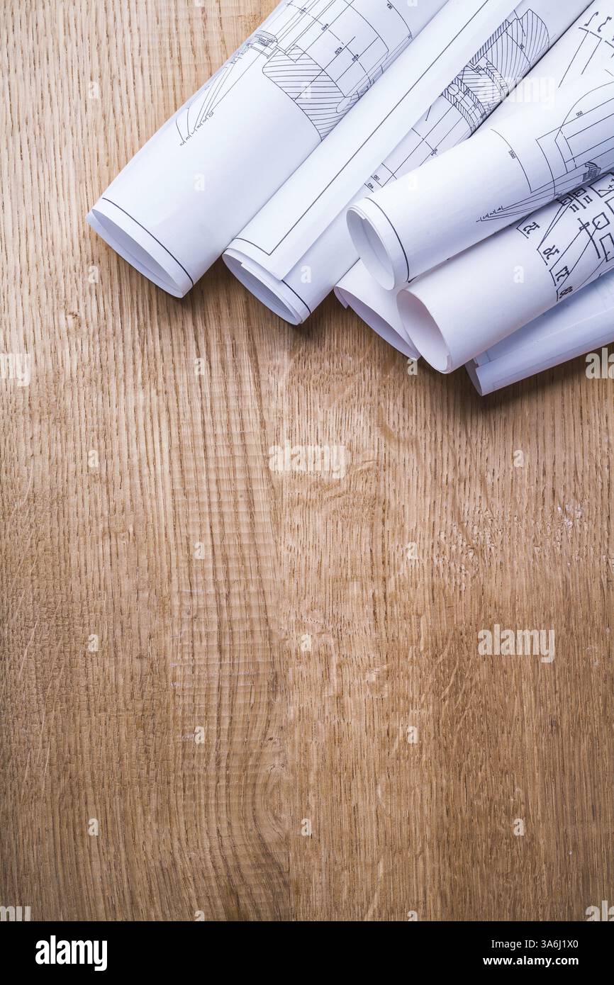 Copyspace image white rolled up blueprints in stack on wooden board ...