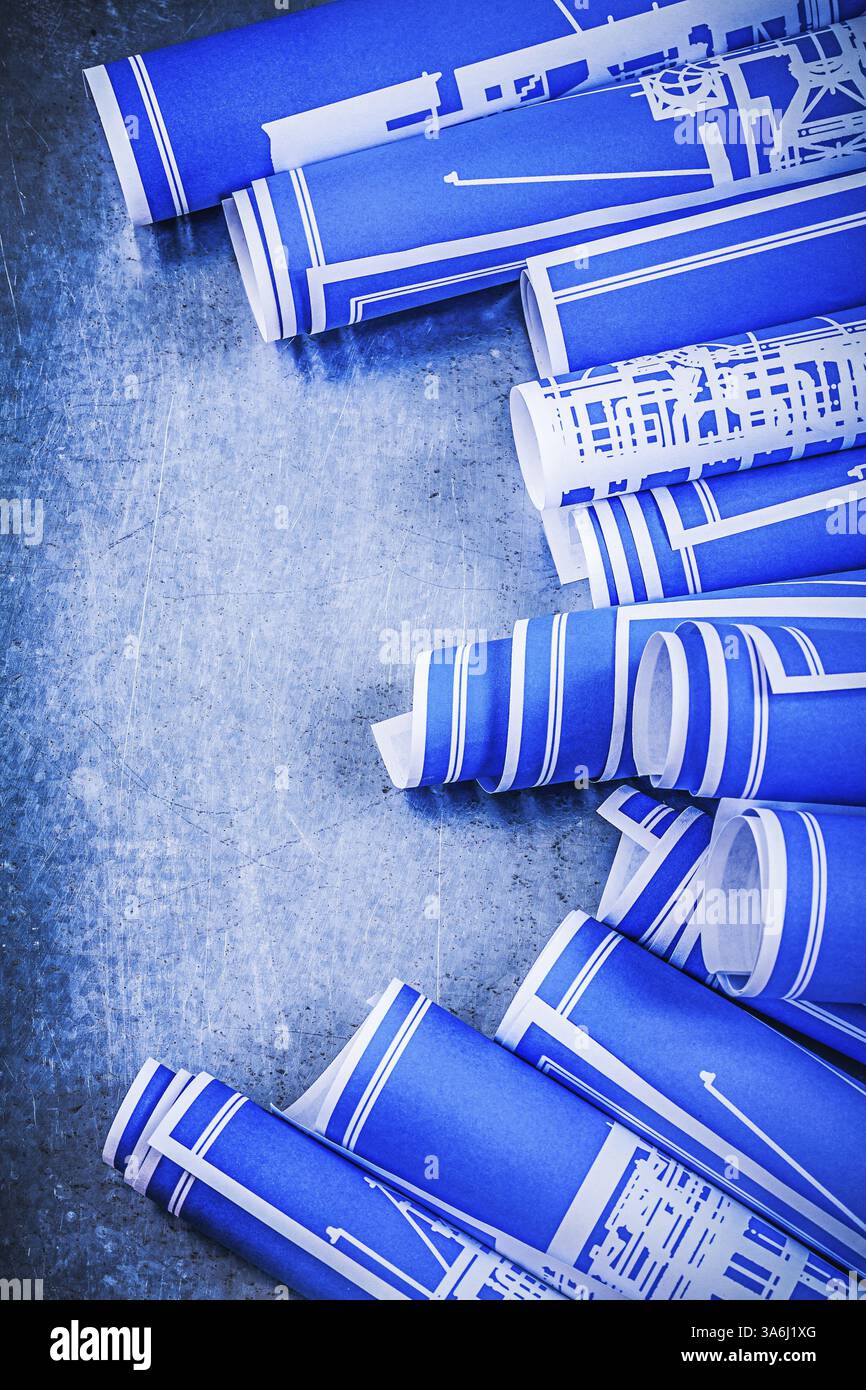 Set of blue rolled construction plans on metallic background ...