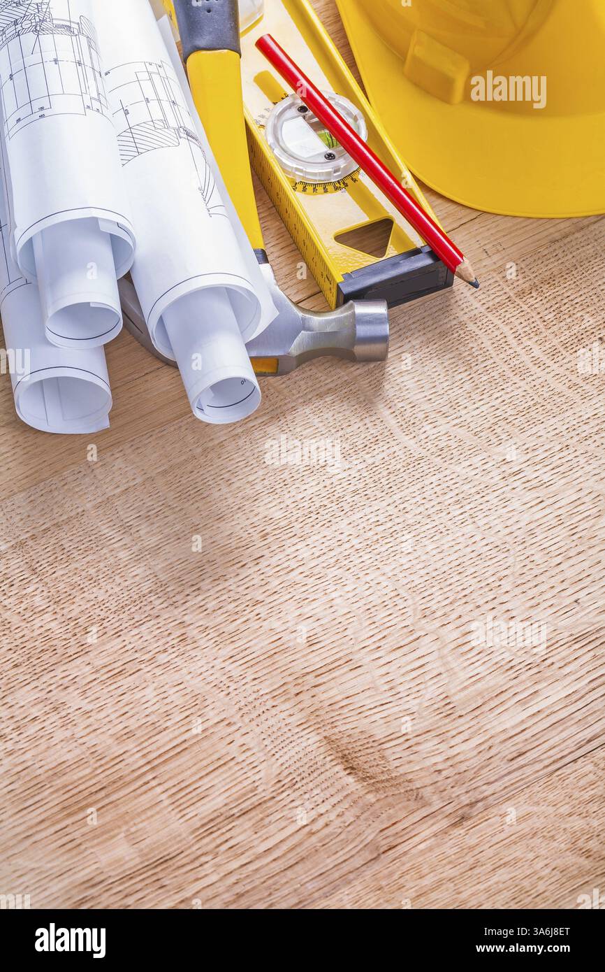 Copyspace image yellow hardhat rolled white blueprints level red pencil ...