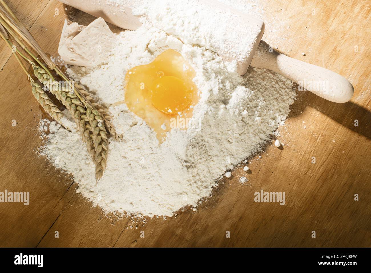Pile of flour, rolling pin and wheat. Egg on flour Stock Photo - Alamy