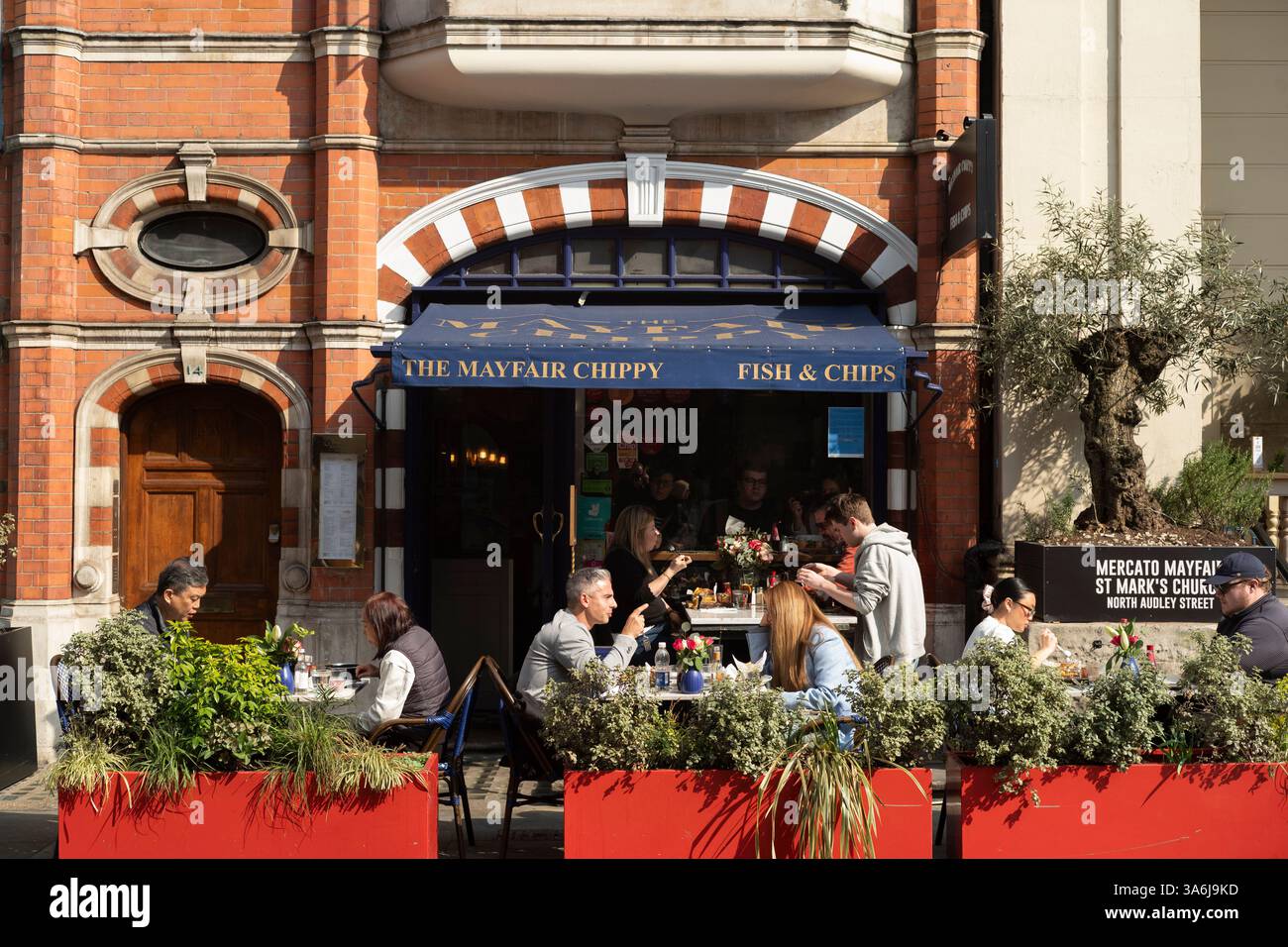 People sit outside The Mayfair Chippy, on a sunny Spring day on North ...