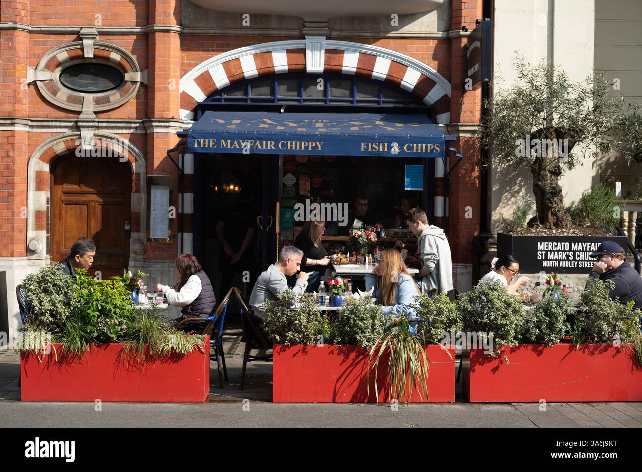 People sit outside The Mayfair Chippy, on a sunny Spring day on North ...