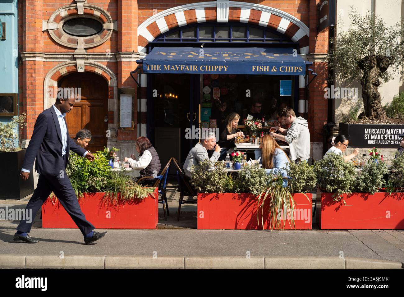 People sit outside The Mayfair Chippy, on a sunny Spring day on North ...