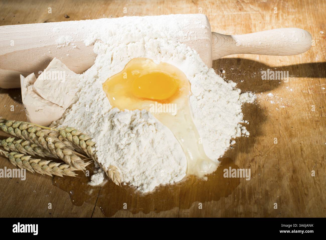 Pile of flour, rolling pin and wheat. Egg on flour Stock Photo - Alamy