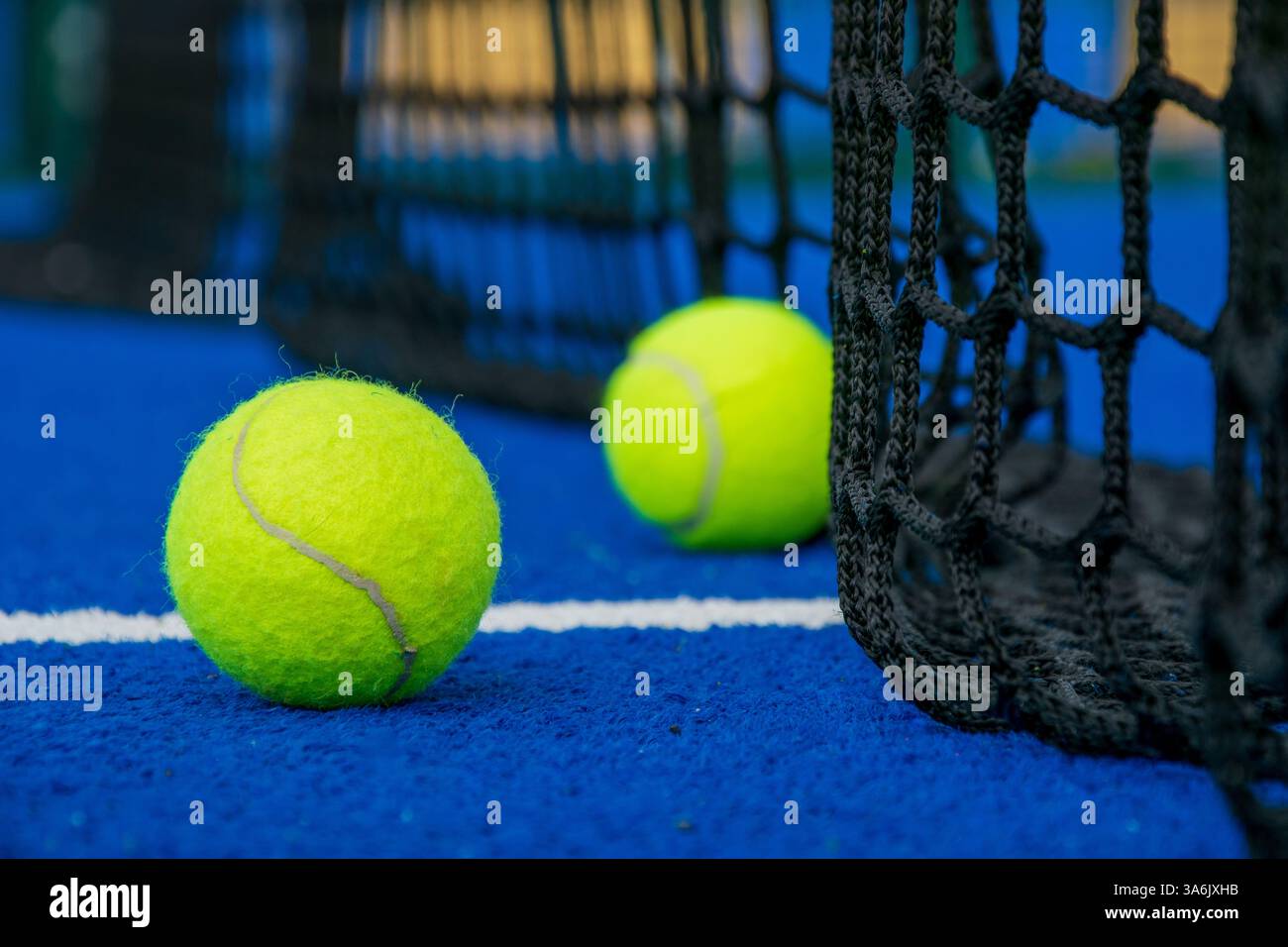 close up view of padel balls and net in a blue padel tennis court ...
