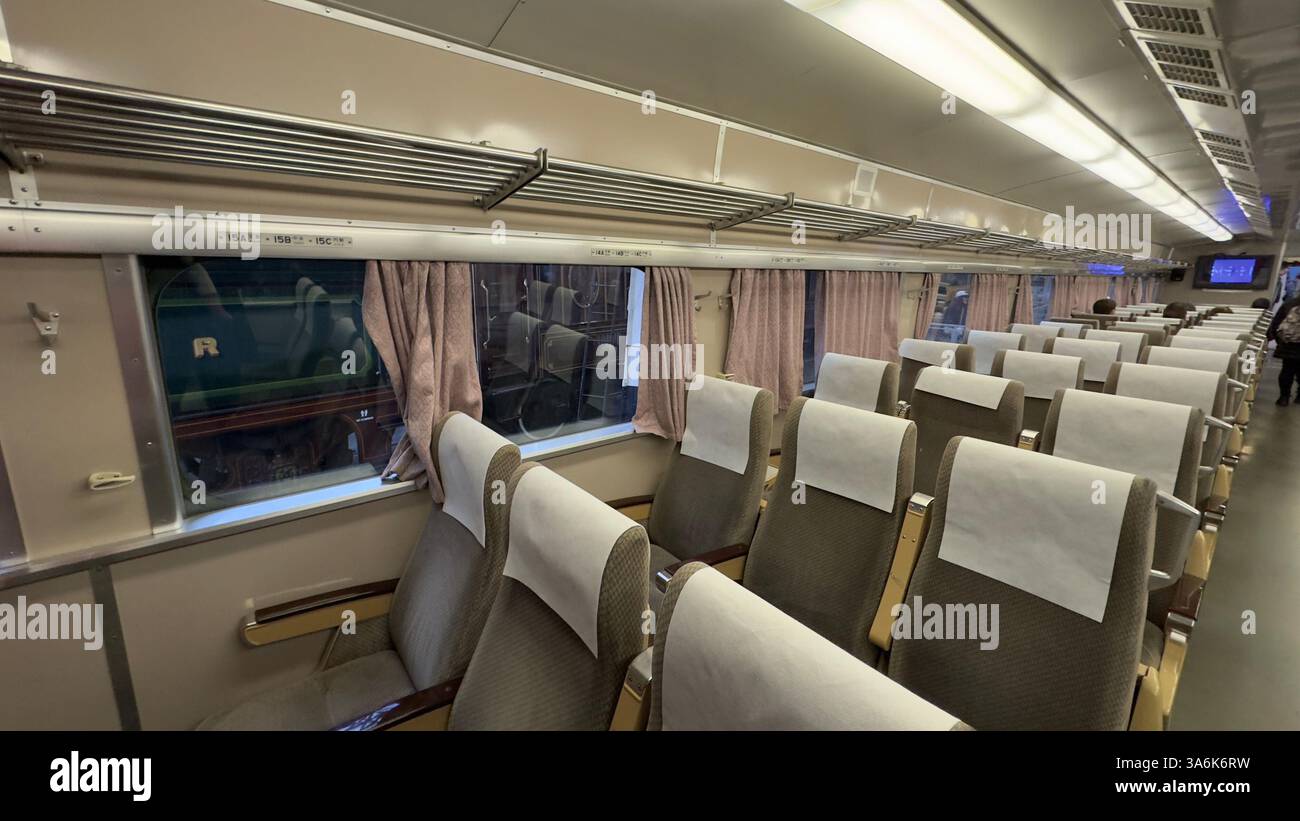 Interior of a train car showing rows of seats with headrests. Windows ...