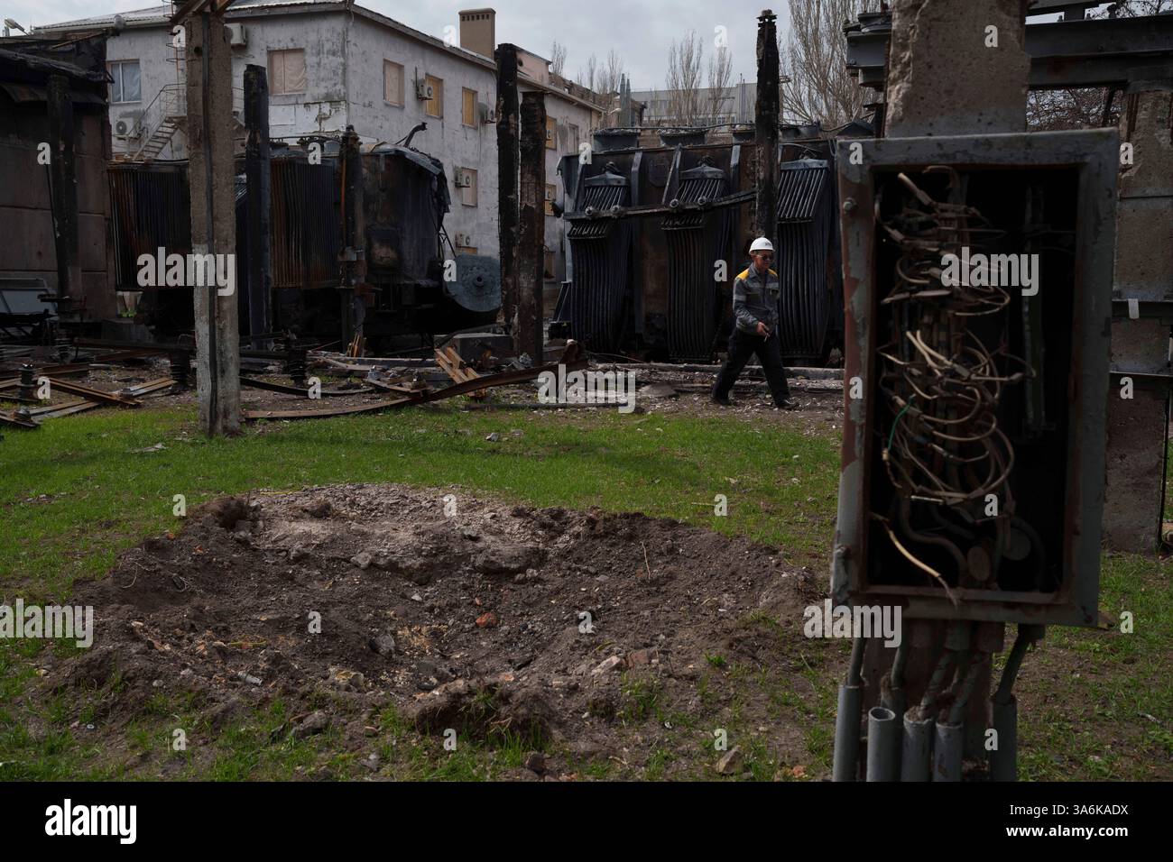 A worker of DTEK company walks in front of transformers of a substation ...