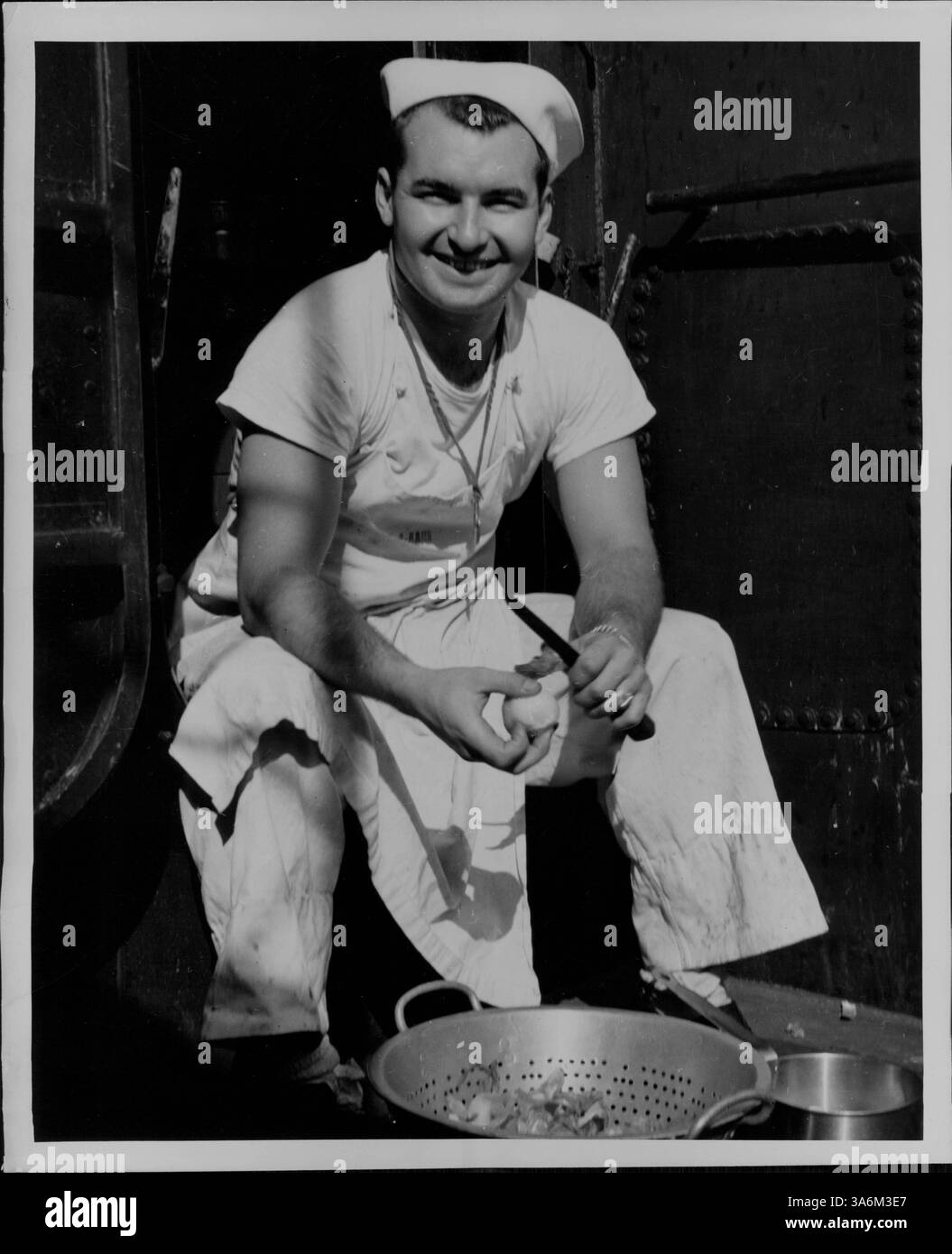 Coast Guardsman Francis Kane, a ship's cook, is seen peeling potatoes ...
