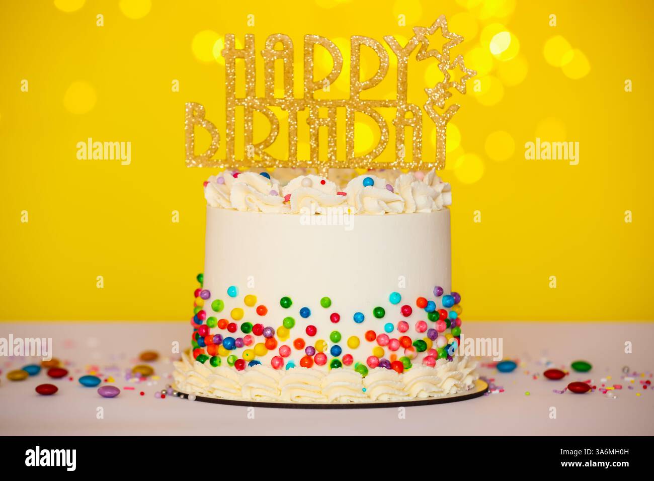 Tasty bento cake with colorful sprinkles and topper on table against ...