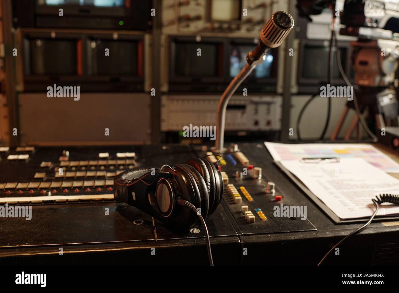 Microphone on sound mixing console with headphones, script on paper ...