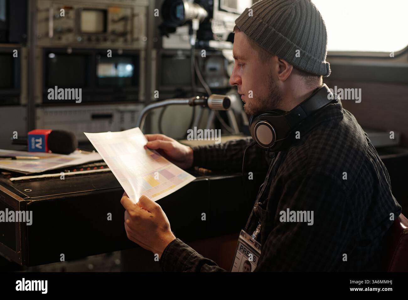 Serious male operator studying information on working paper document ...