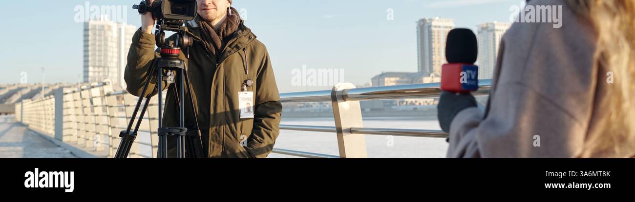 Header of young man in casual apparel using professional video camera ...