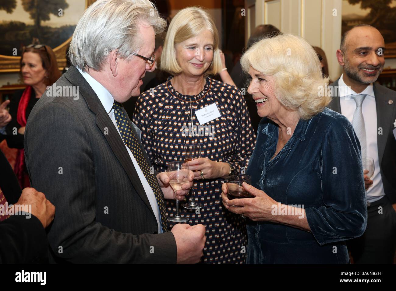 Queen Camilla speaks to Robert Hardman and Joanna Prior during a ...