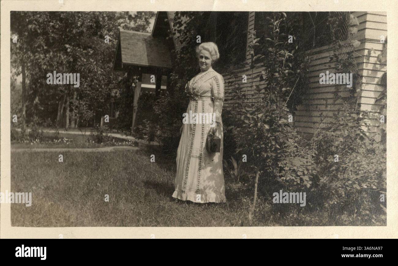 A historical photograph of Mrs. Francis W. Little standing in her yard, showcasing a moment of ...