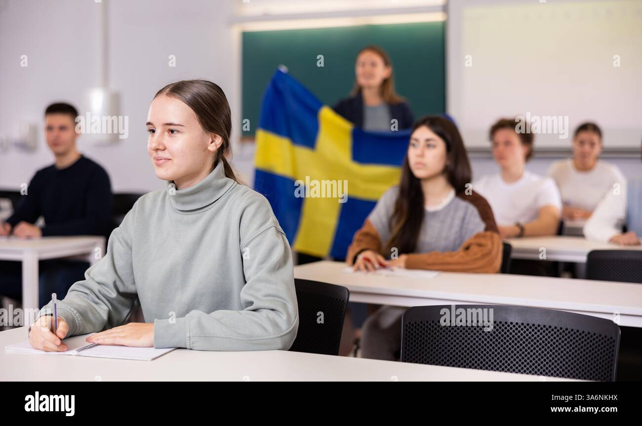 Teacher stands behind students with flag of Sweden Stock Photo - Alamy