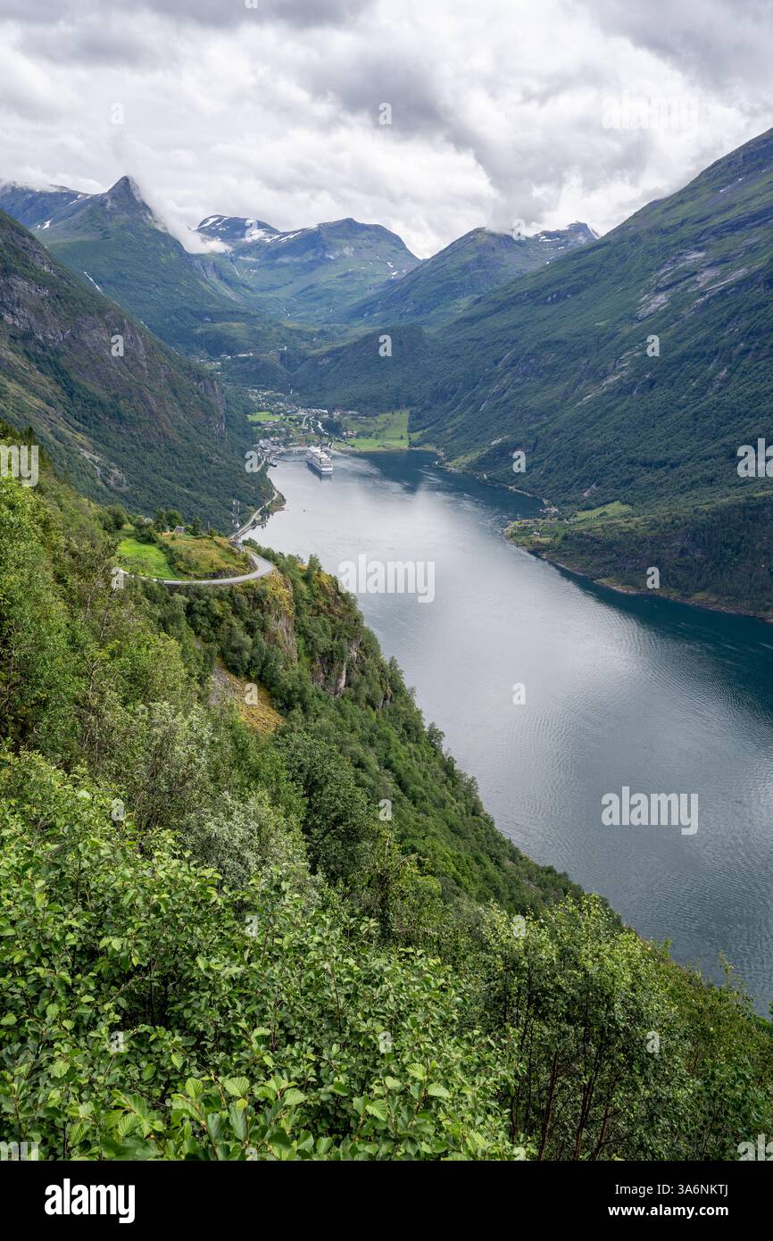 View of Geirangerfjord with Geiranger village with a cruise ship docked in its harbor at ...