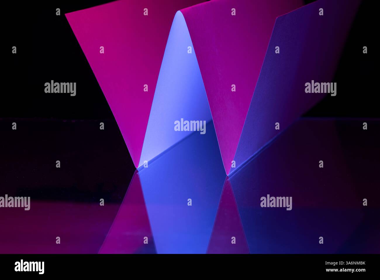 A striking arrangement of pink and blue paper forms two overlapping ...