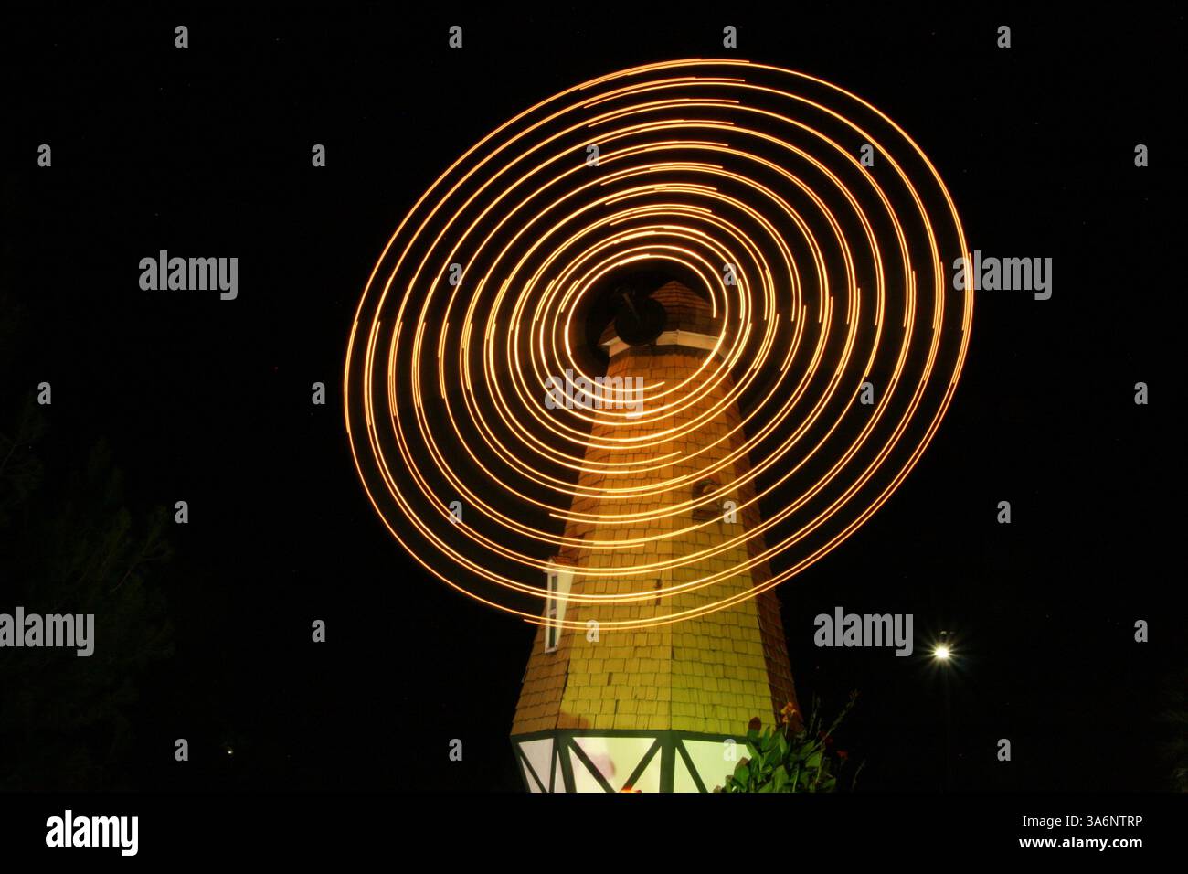 The lights on a miniature golf windmill makes concentric circles as it ...
