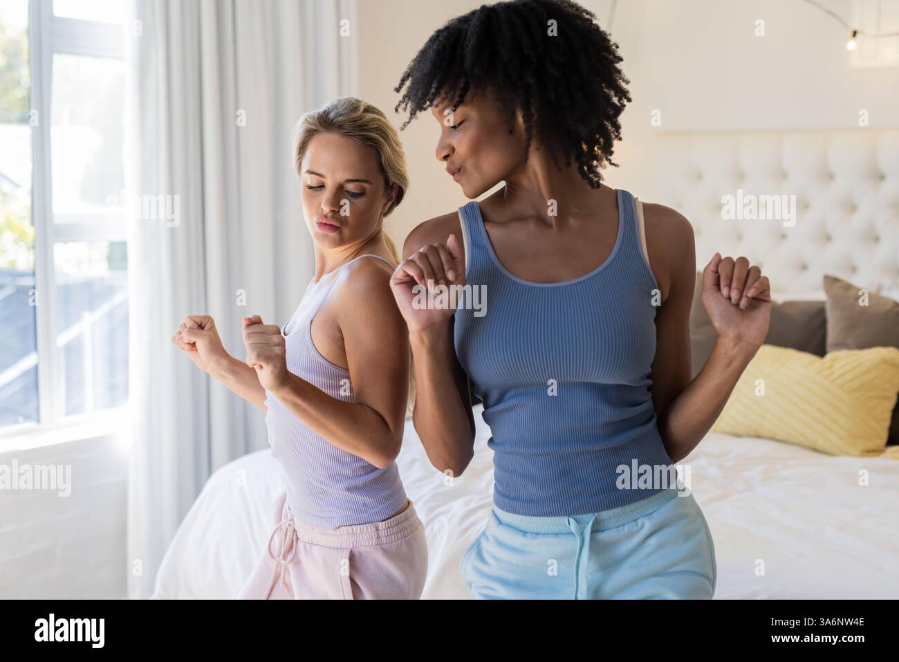Two women dancing joyfully in bedroom, enjoying friendship and fun ...