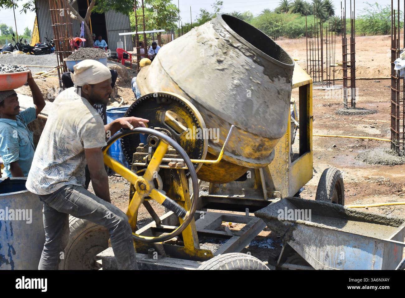 Construction worker operating a concrete mixer at a building site Stock ...