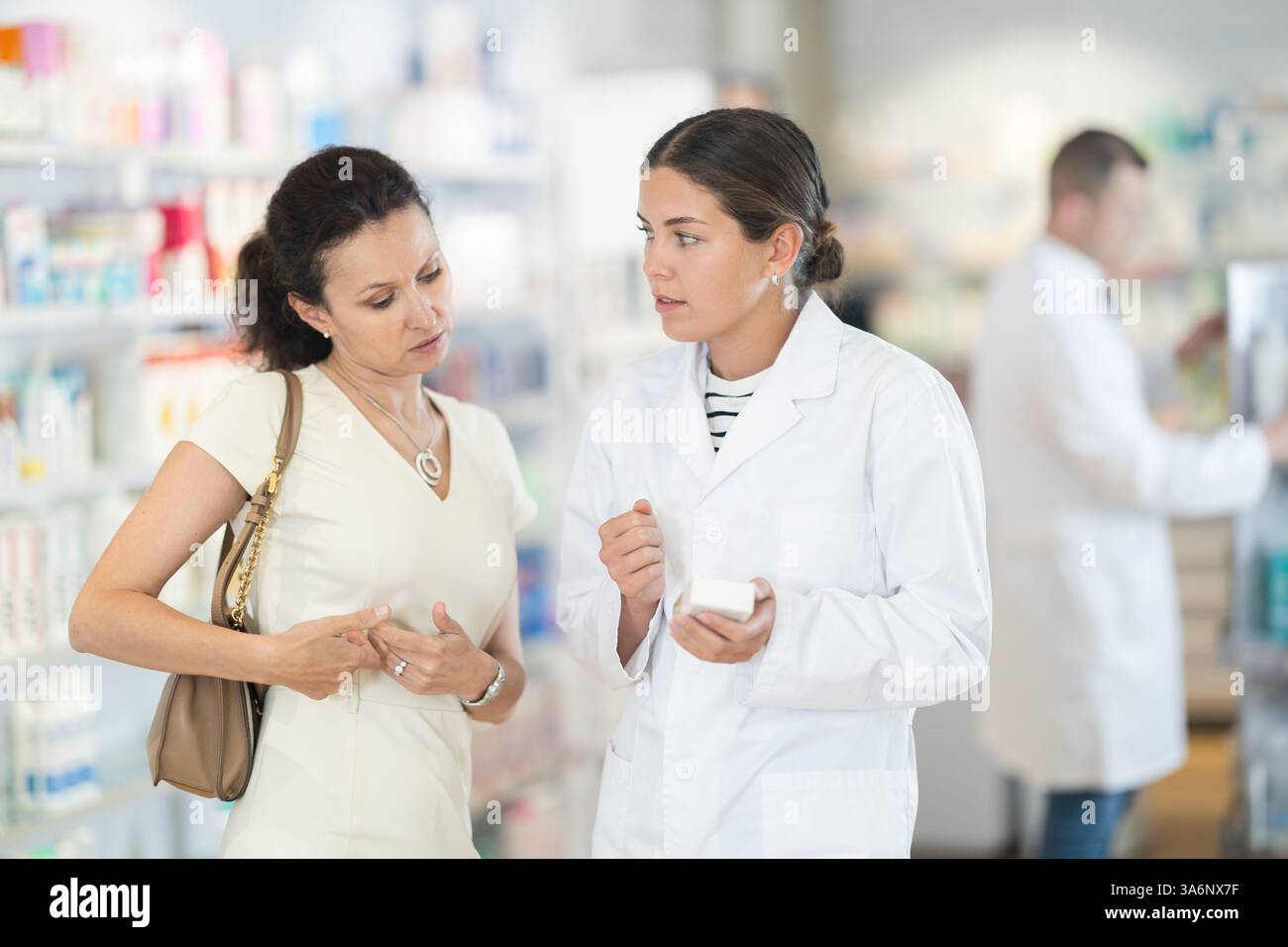 Female pharmacist advises medicine for heart pain to woman Stock Photo ...
