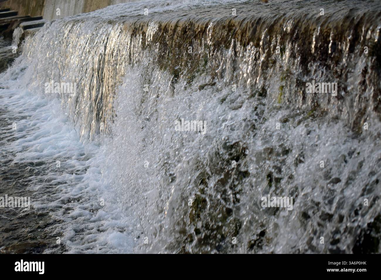 A close-up view of a fast flowing stream over the edge of an escarpment ...