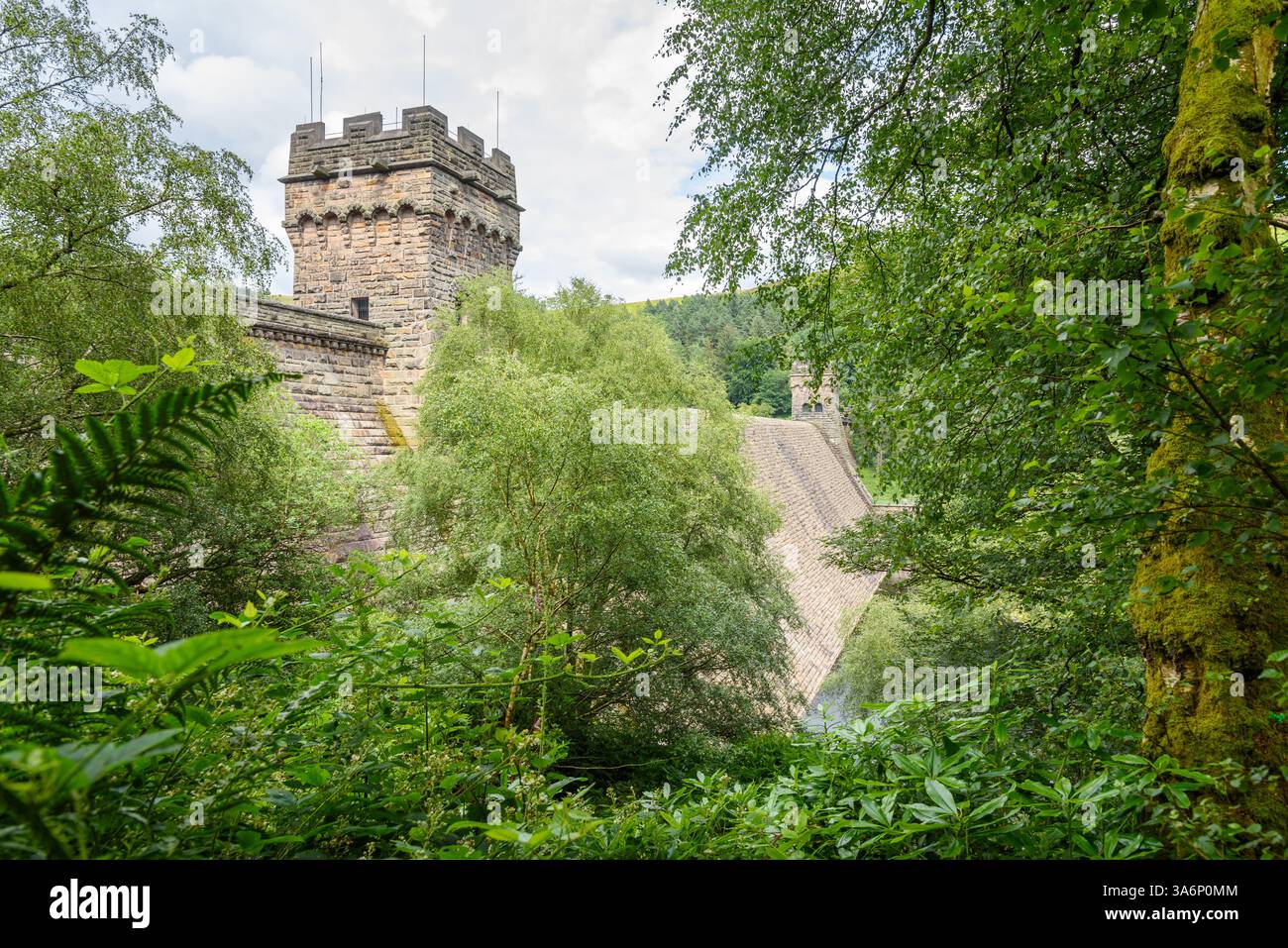 Old stone dam with a tower on a partly cloudy summer day Stock Photo ...