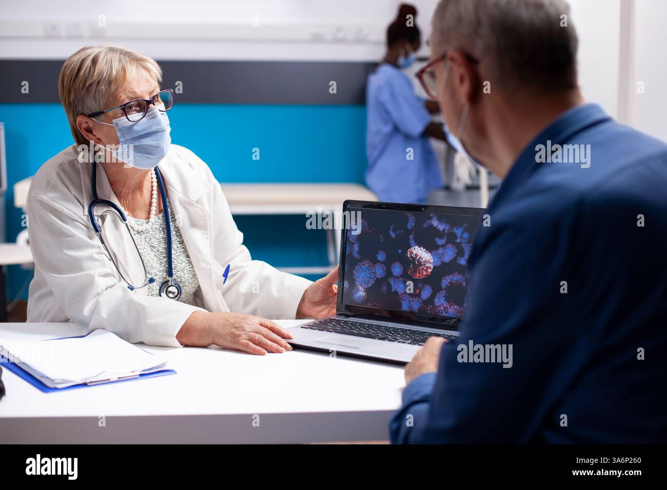In hospital room, laptop shows viral cells on screen while retired ...
