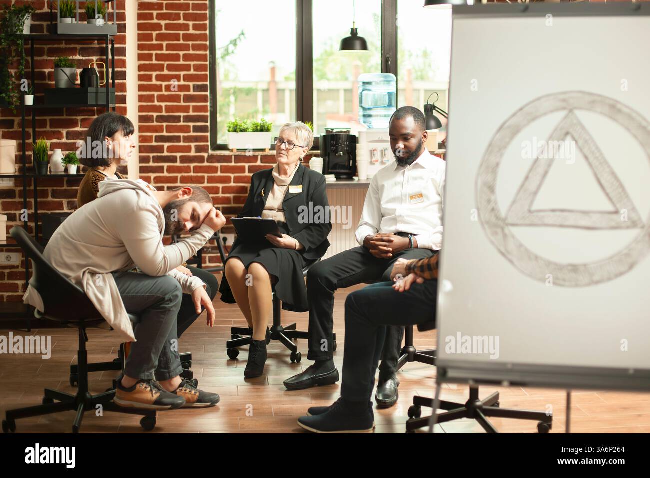 Group of alcoholics gather in aa meeting room with symbol displayed on ...