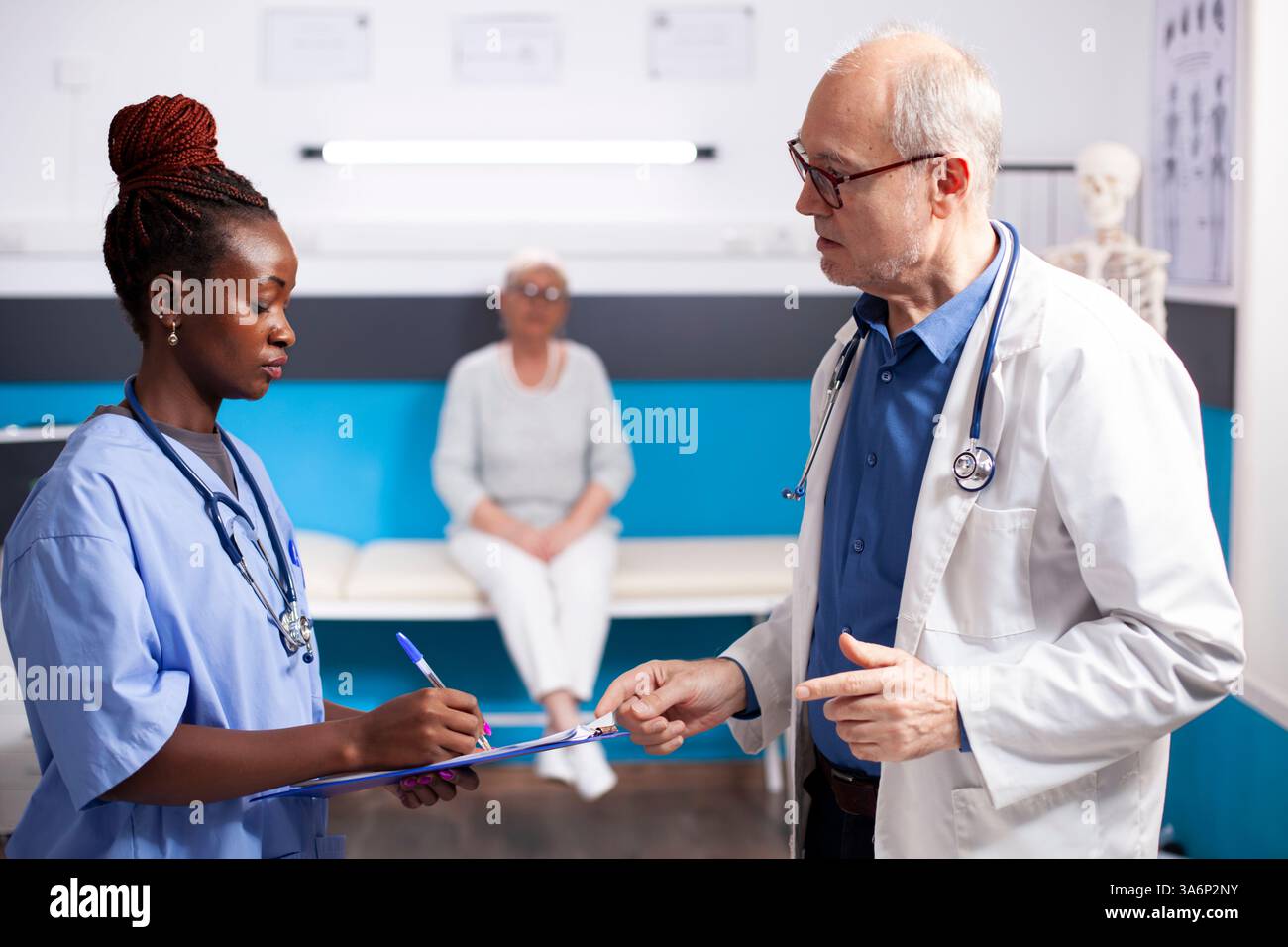 Young nurse with clipboard listens attentively as senior doctor ...