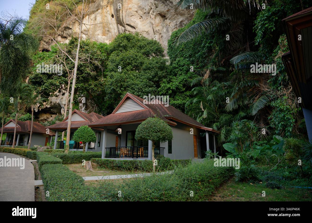 Bungalows nestled at the base of a limestone cliff in Tonsai ...