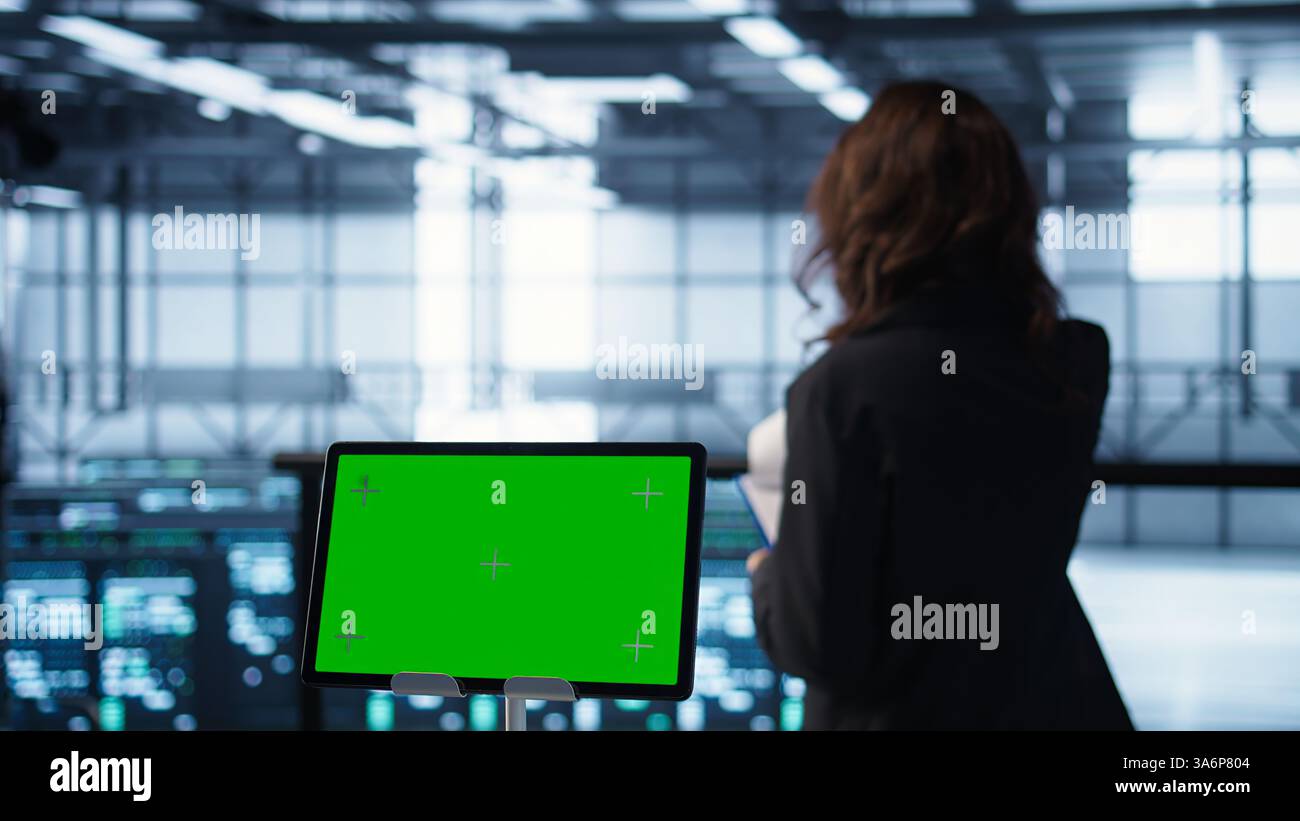 Close up of chroma key tablet and teamworking programmers in server room adjusting power ...
