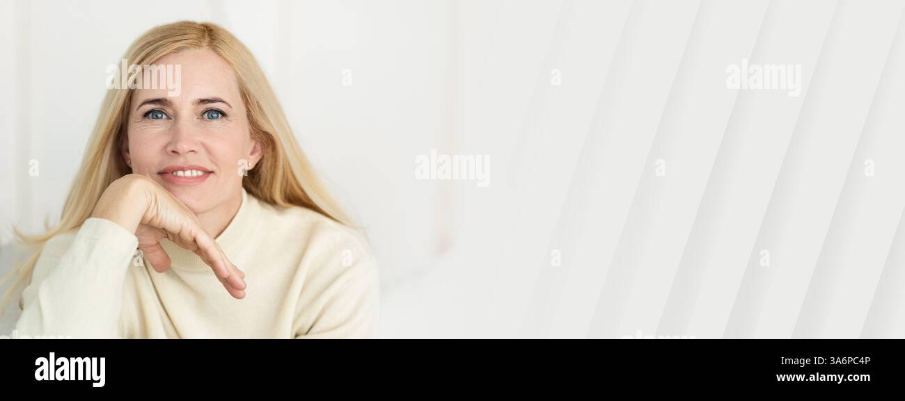 Woman With Long Blonde Hair Smiles Softly, Resting Her Chin on Her Hand ...