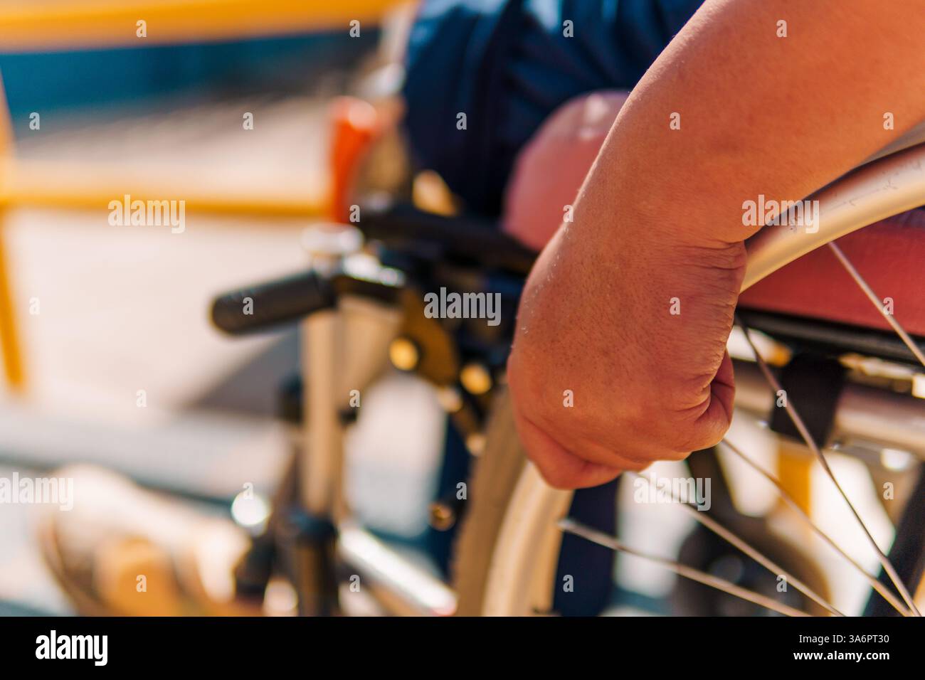 View of the hands of a woman with a prosthesis in a wheelchair, driving ...