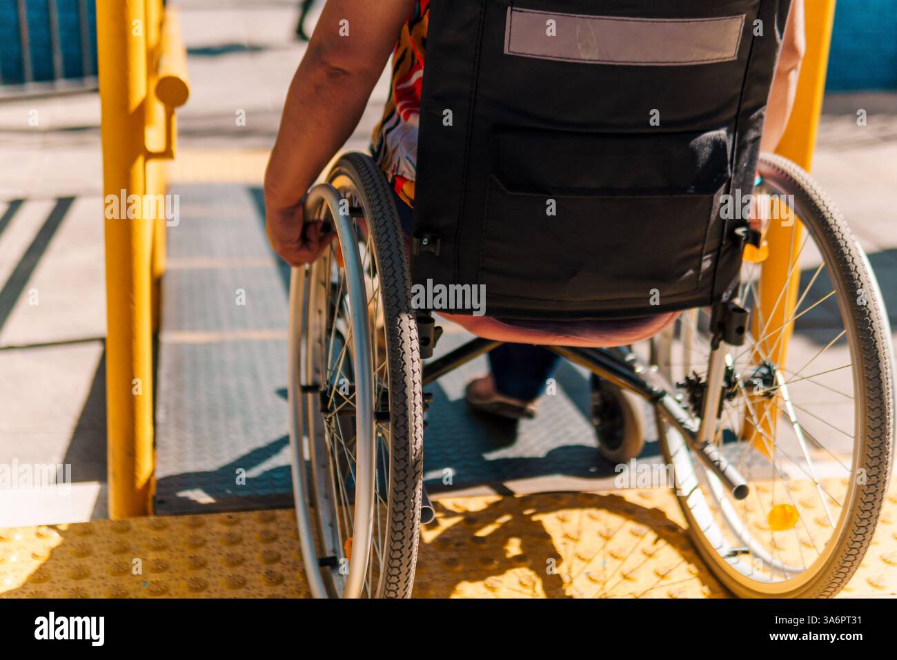 View of the hands of a woman with a prosthesis in a wheelchair, driving ...