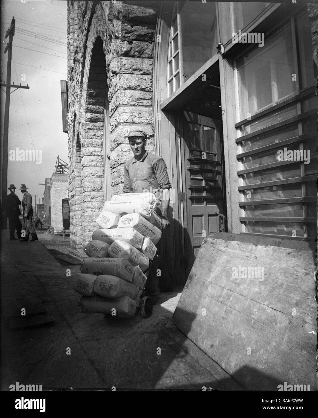This image shows a worker at the Pillsbury Anchor Mill Annex, pushing a ...