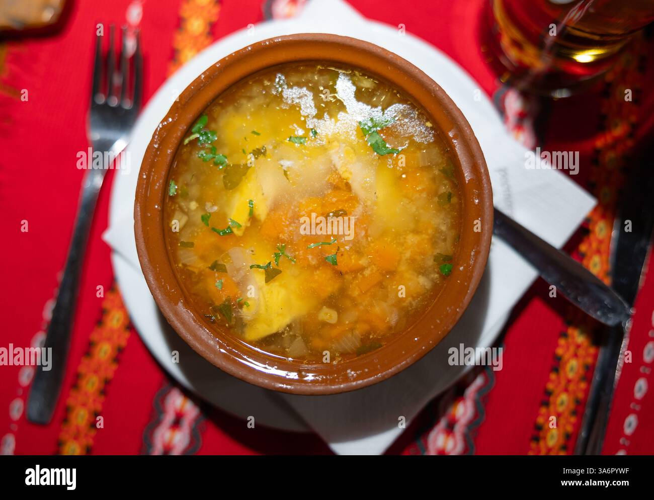 Deep clay bowl with Bulgarian fish and vegetable soup, complemented by ...